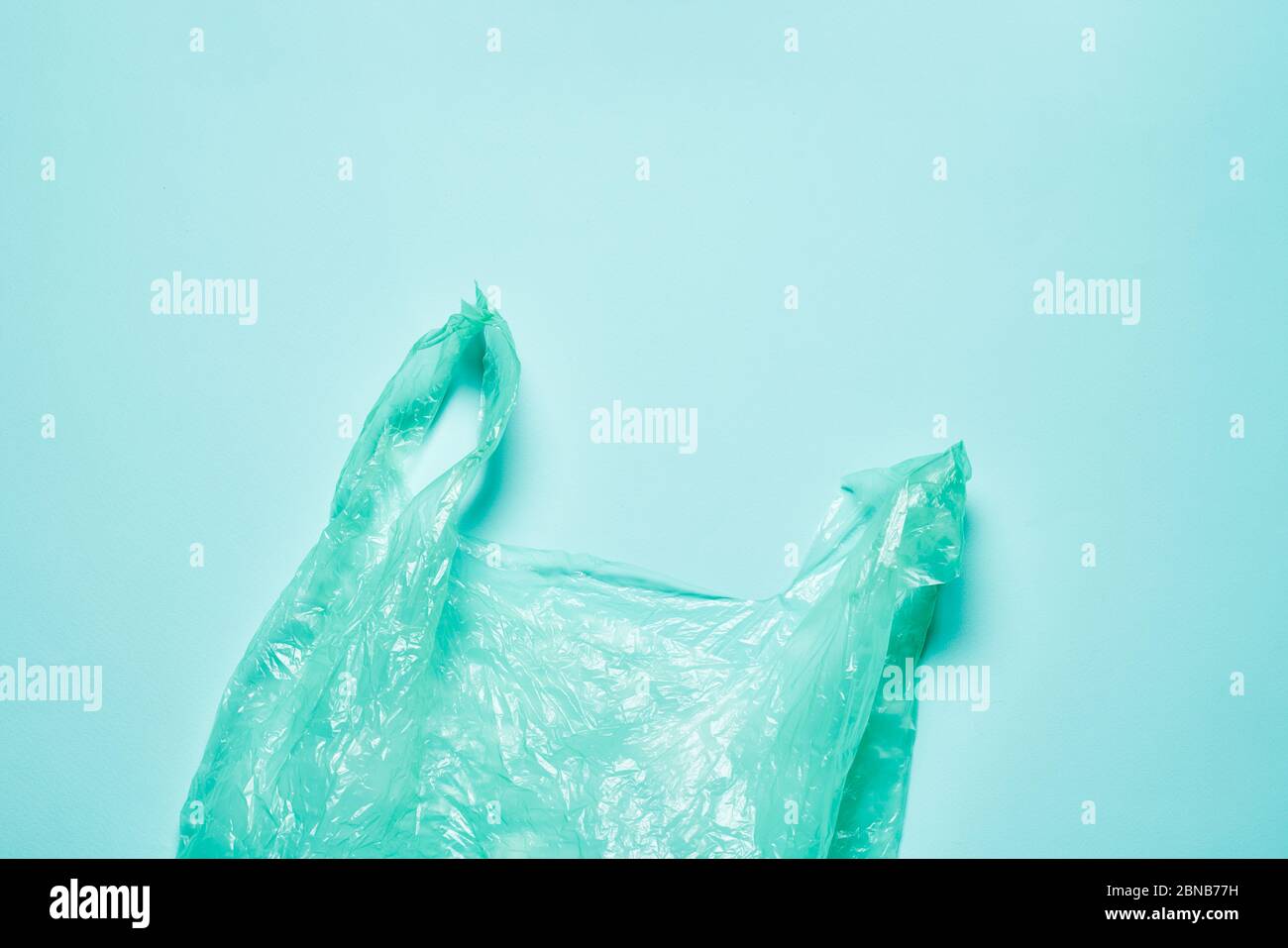 Empty plastic green bag over green background Stock Photo - Alamy