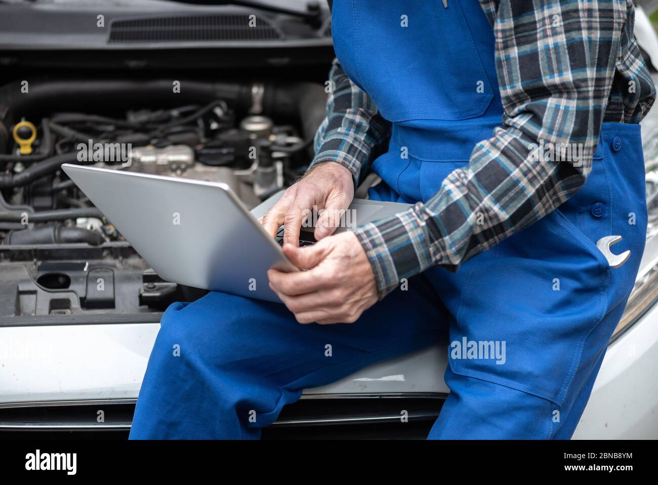 Car mechanic using laptop for checking car engine Stock Photo - Alamy