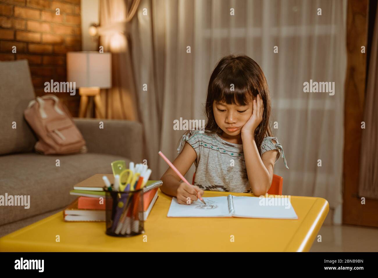 portrait of serious kid studying at home by her self Stock Photo - Alamy