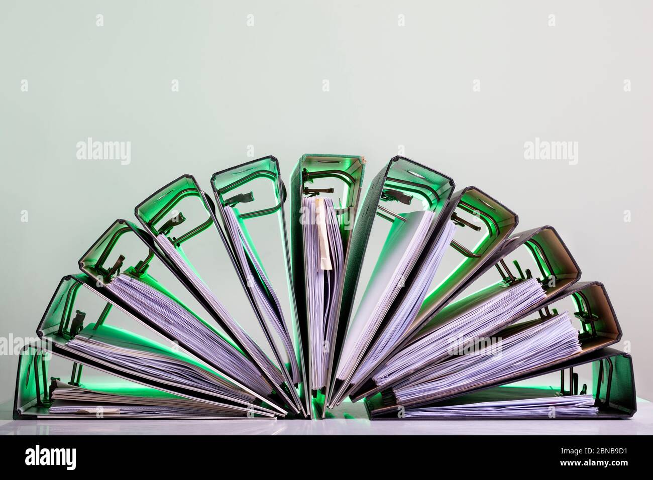 Half circle of office folders with archived paperwork in green light ...