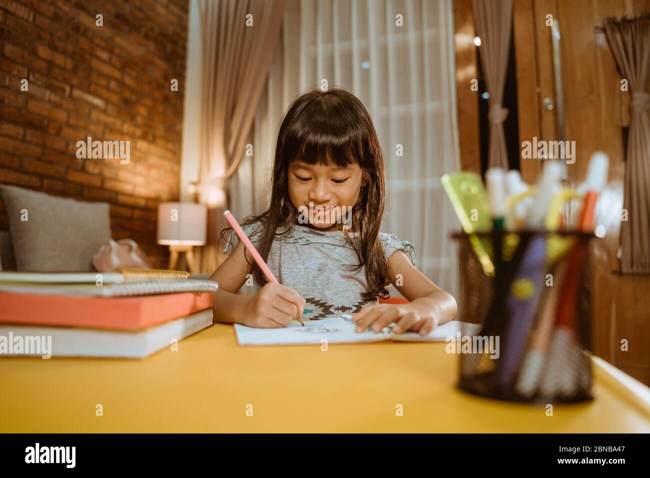 happy asian child studying at home in the evening Stock Photo - Alamy
