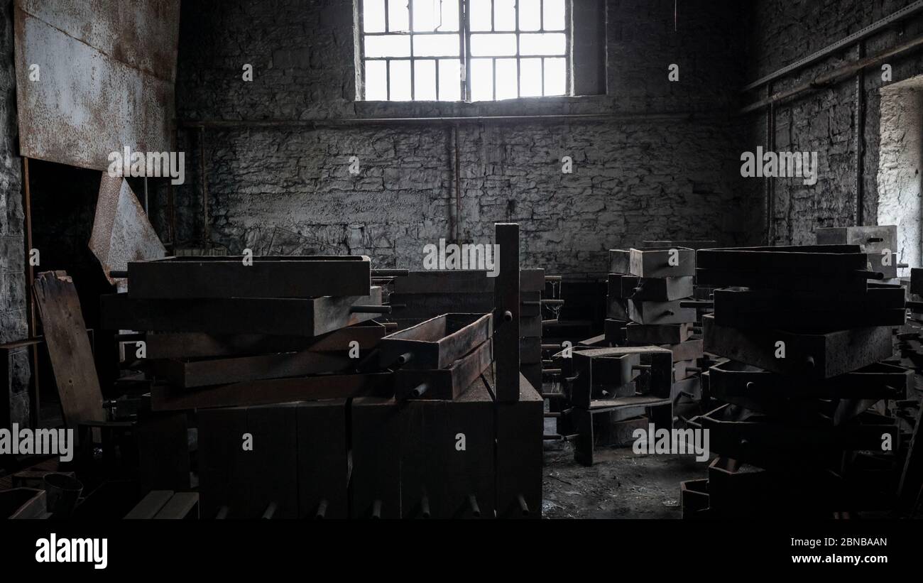 Messy room with stacks of metal and a concrete brick wall of a building ...