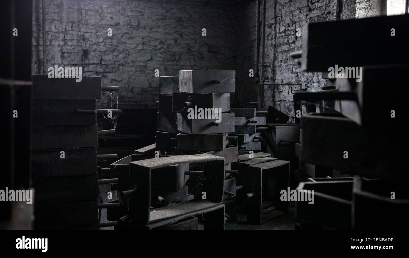 Messy room with stacks of metal and a concrete brick wall of a building ...