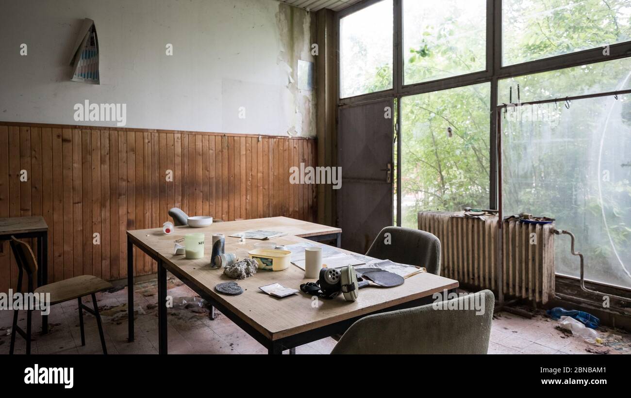 Glass window with a messy table inside of an abandoned room of a ...