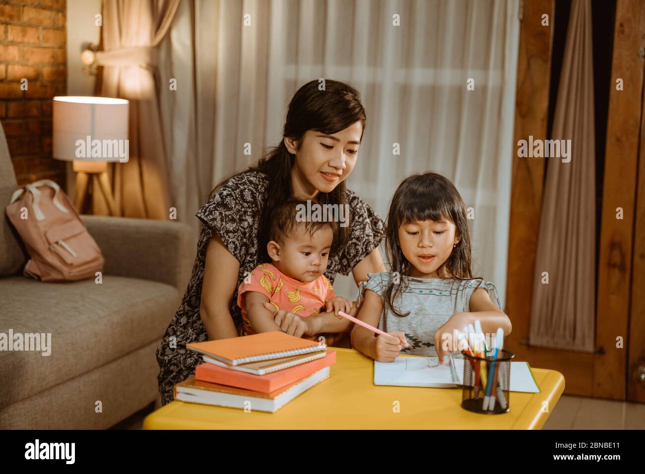 children studying at home during self isolation at home in the evening ...