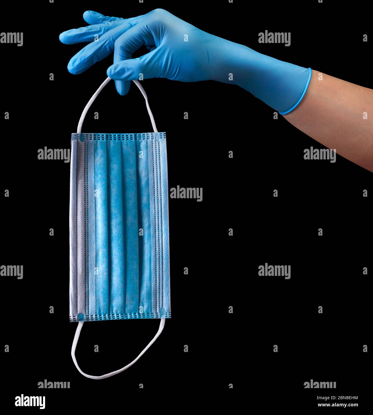 Doctor's hand in medical gloves wearing a mask isolated on black Stock ...