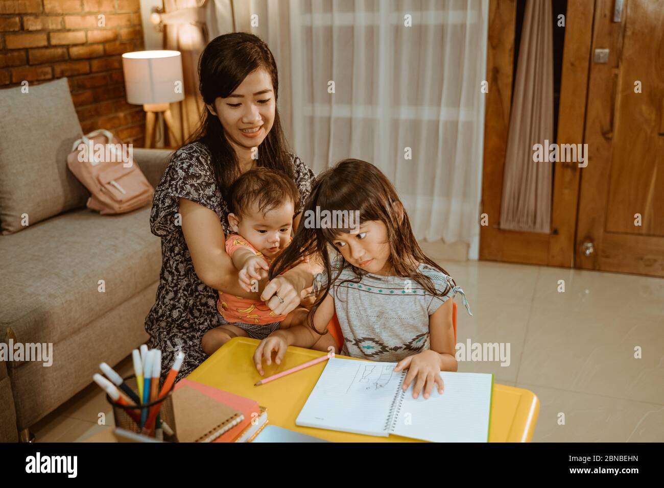 study disturbance. child studying at home in the evening with mother ...