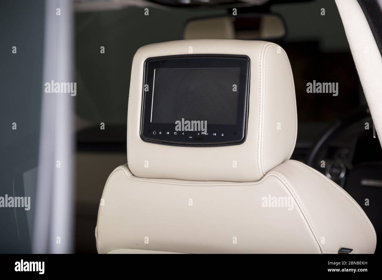 Closeup shot of a small screen on the back of the seat of a modern car ...