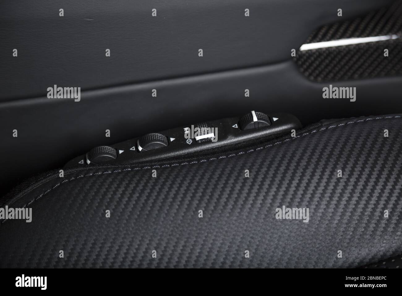 Closeup shot of a door handle with power windows control buttons of a ...