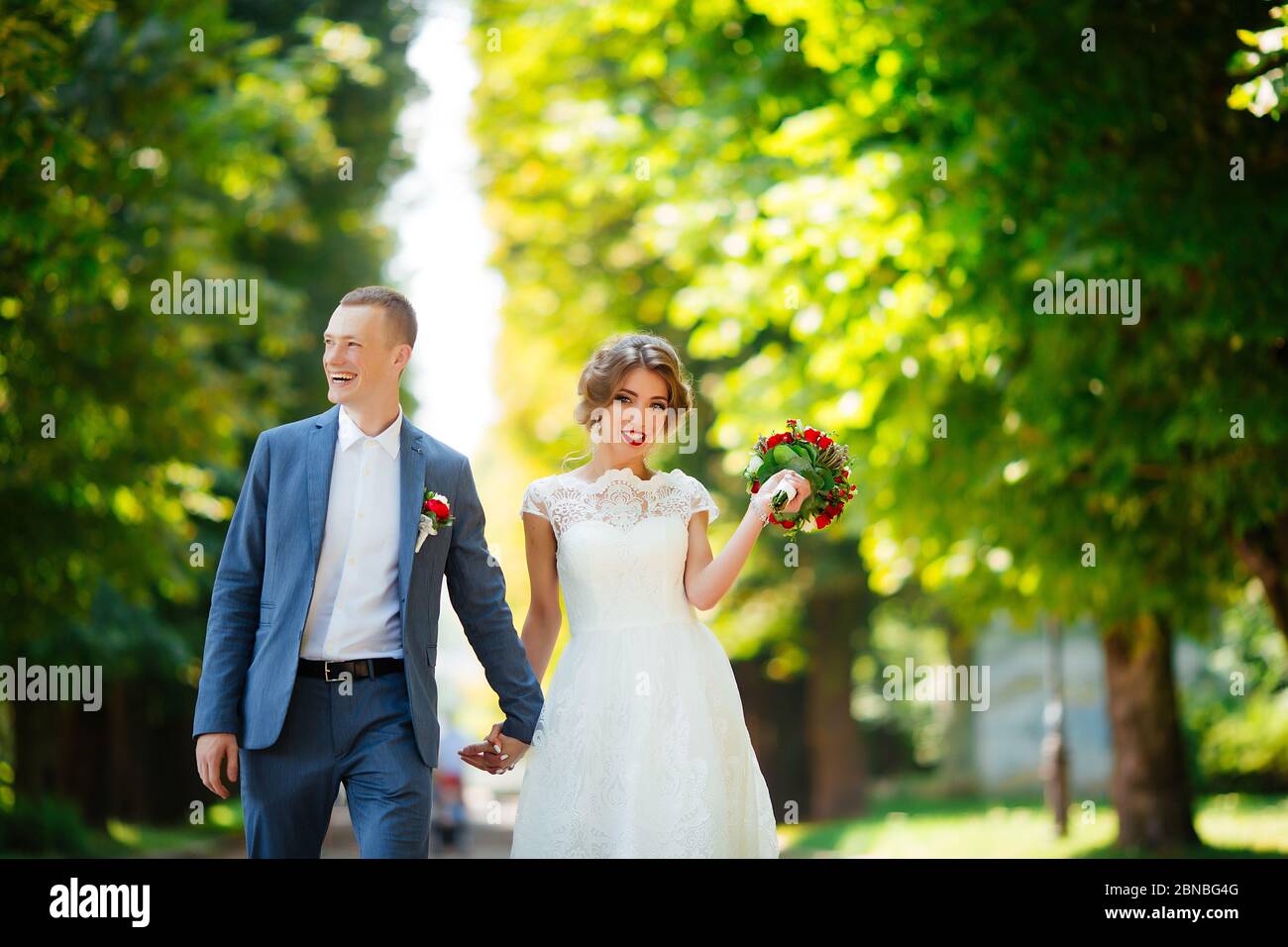 Bride and groom on their wedding day, walking outdoors in nature Stock ...