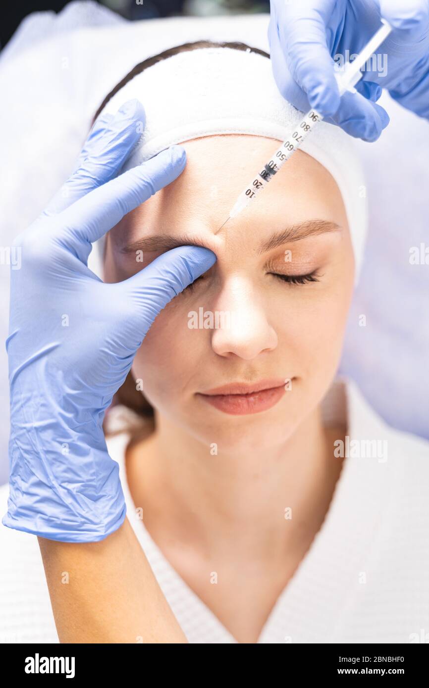 Pretty woman getting injection into the forehead Stock Photo - Alamy