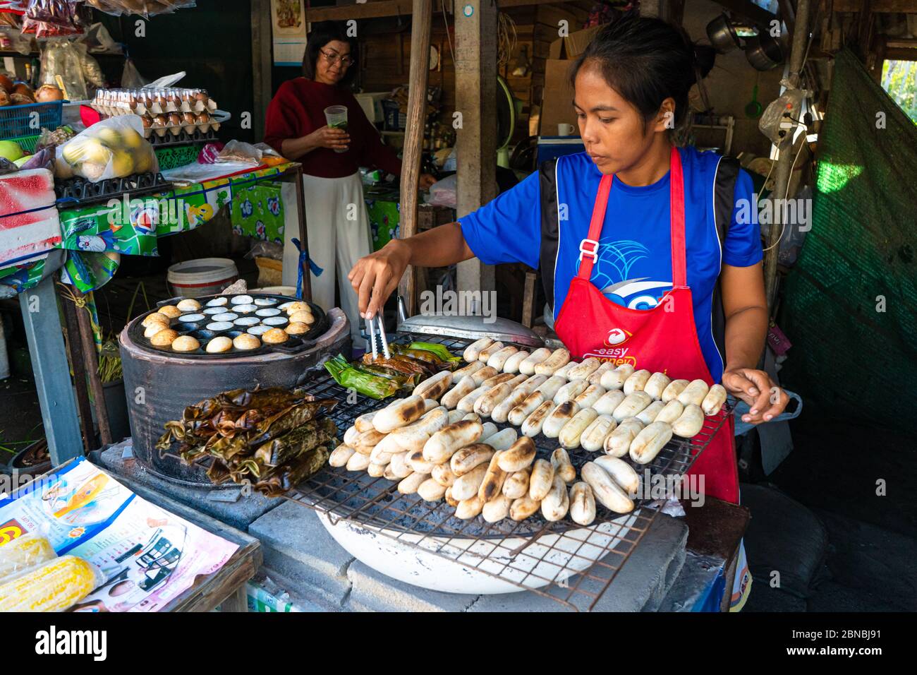 A street food vendor in Asia sells fried bananas and other snacks Stock ...