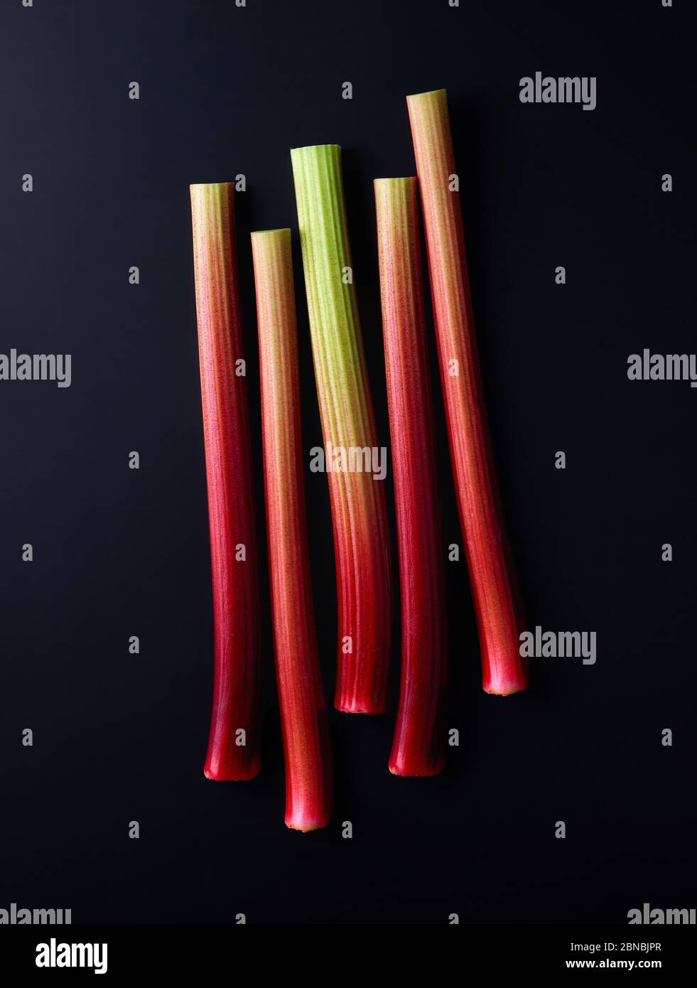 Fresh rhubarb stalks on black background, top view Stock Photo - Alamy
