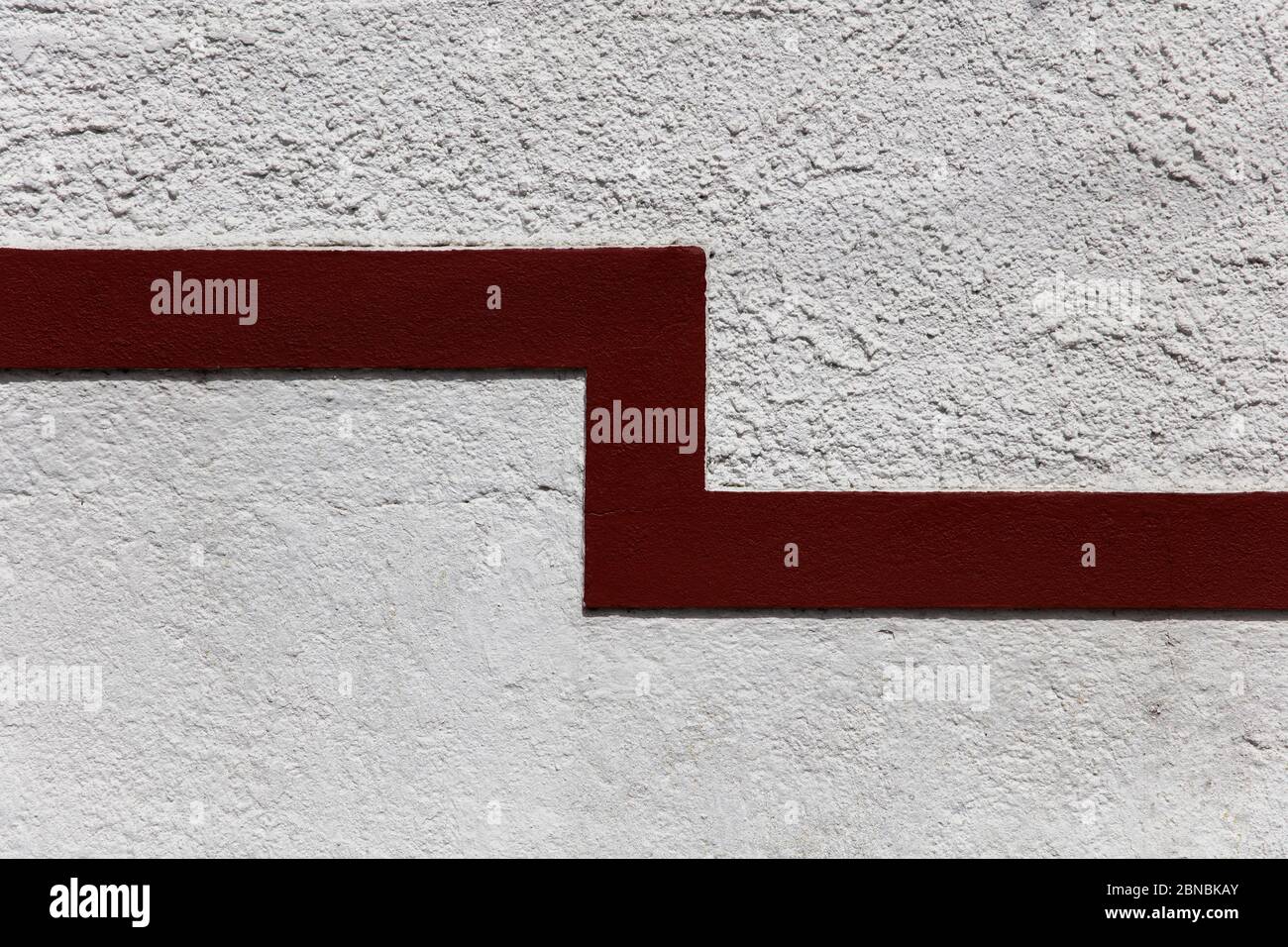 Red line on a white facade as a divider between different grades of ...