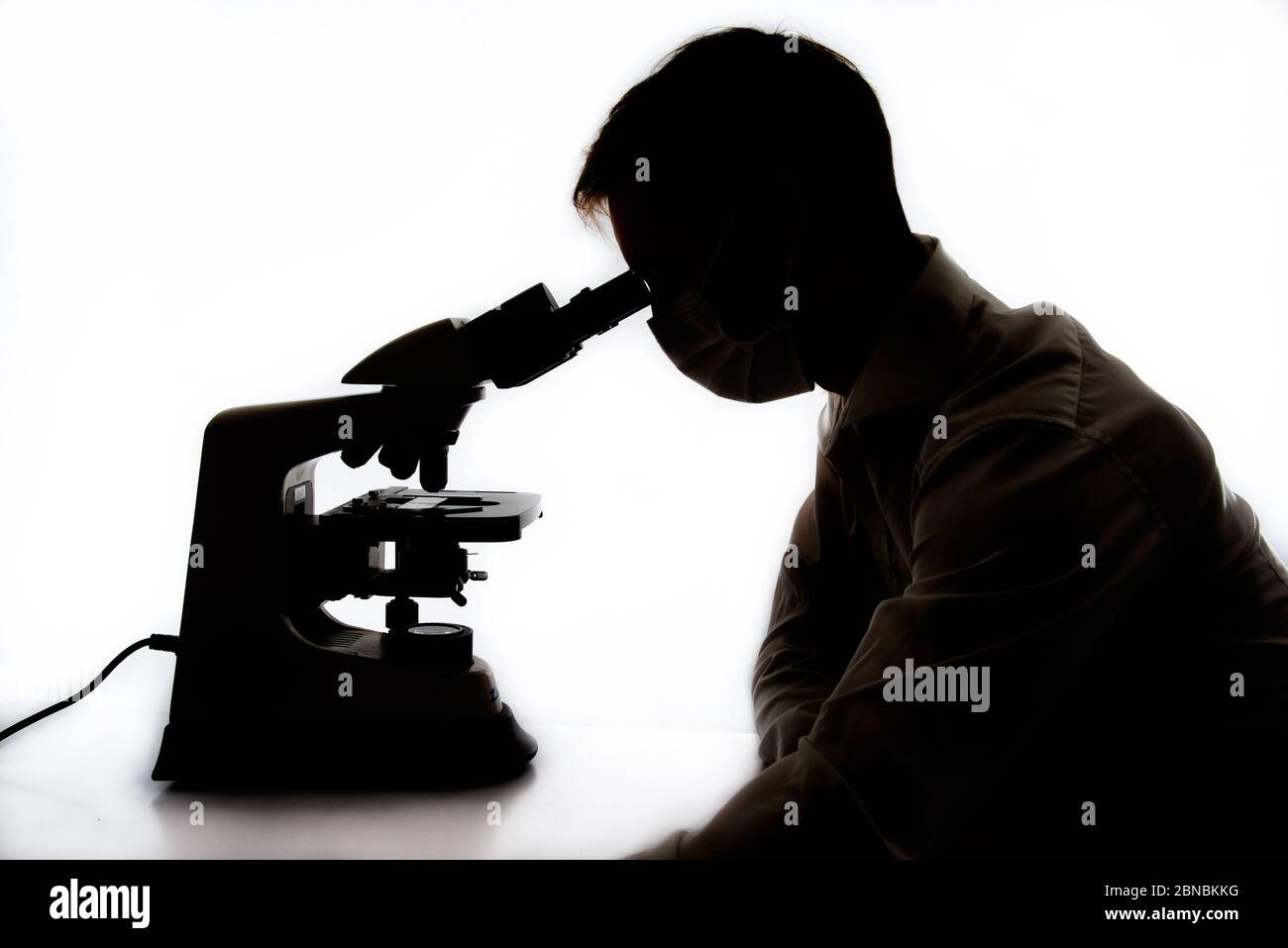 Silhouette of a white male scientist using a binocular microscope Stock ...