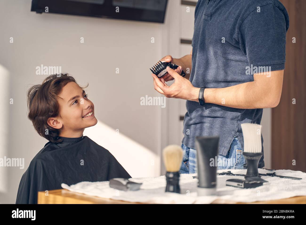 Little boy looking at man and smiling Stock Photo - Alamy