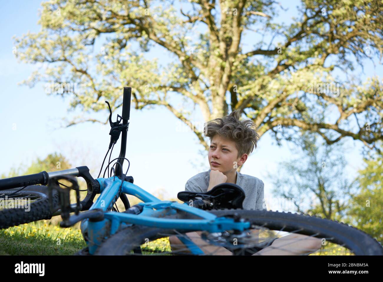Handsome teenage boy having a break during a bike tour being in a ...