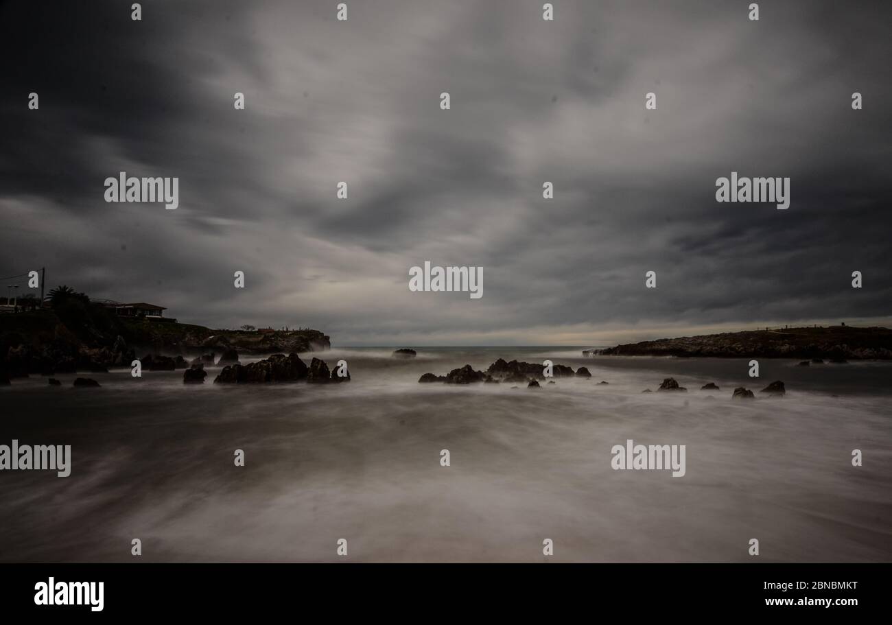 Long exposure shot of the seaside surrounded by cliffs and numerous ...