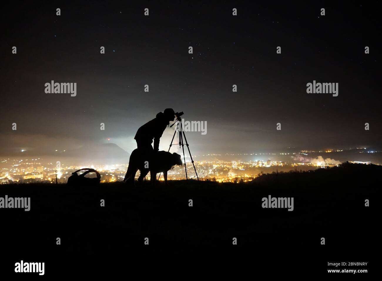 Silhouette of a man a dog and a camera at night Stock Photo - Alamy