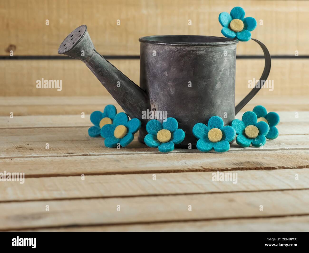 Metal watering can decorated with flowers Stock Photo - Alamy