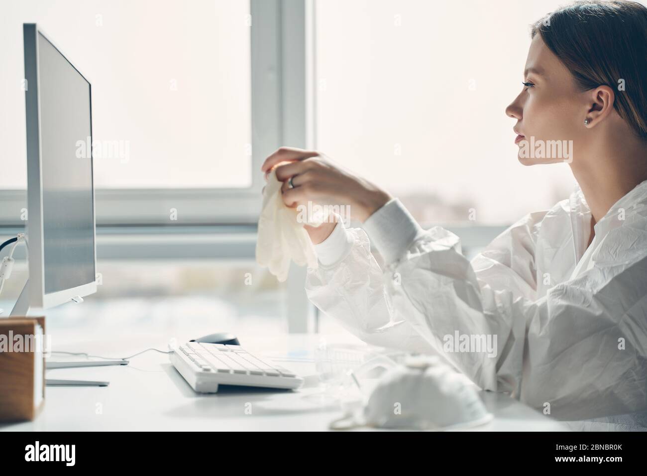 Charming lady sitting at the table with computer at work Stock Photo ...