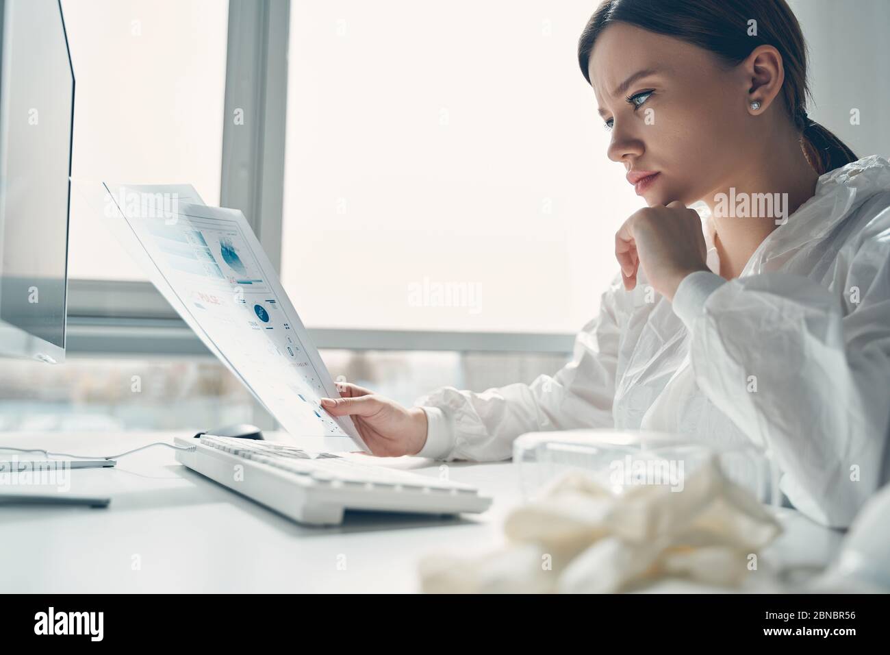 Charming lady analyzing patient data and current indicators Stock Photo ...