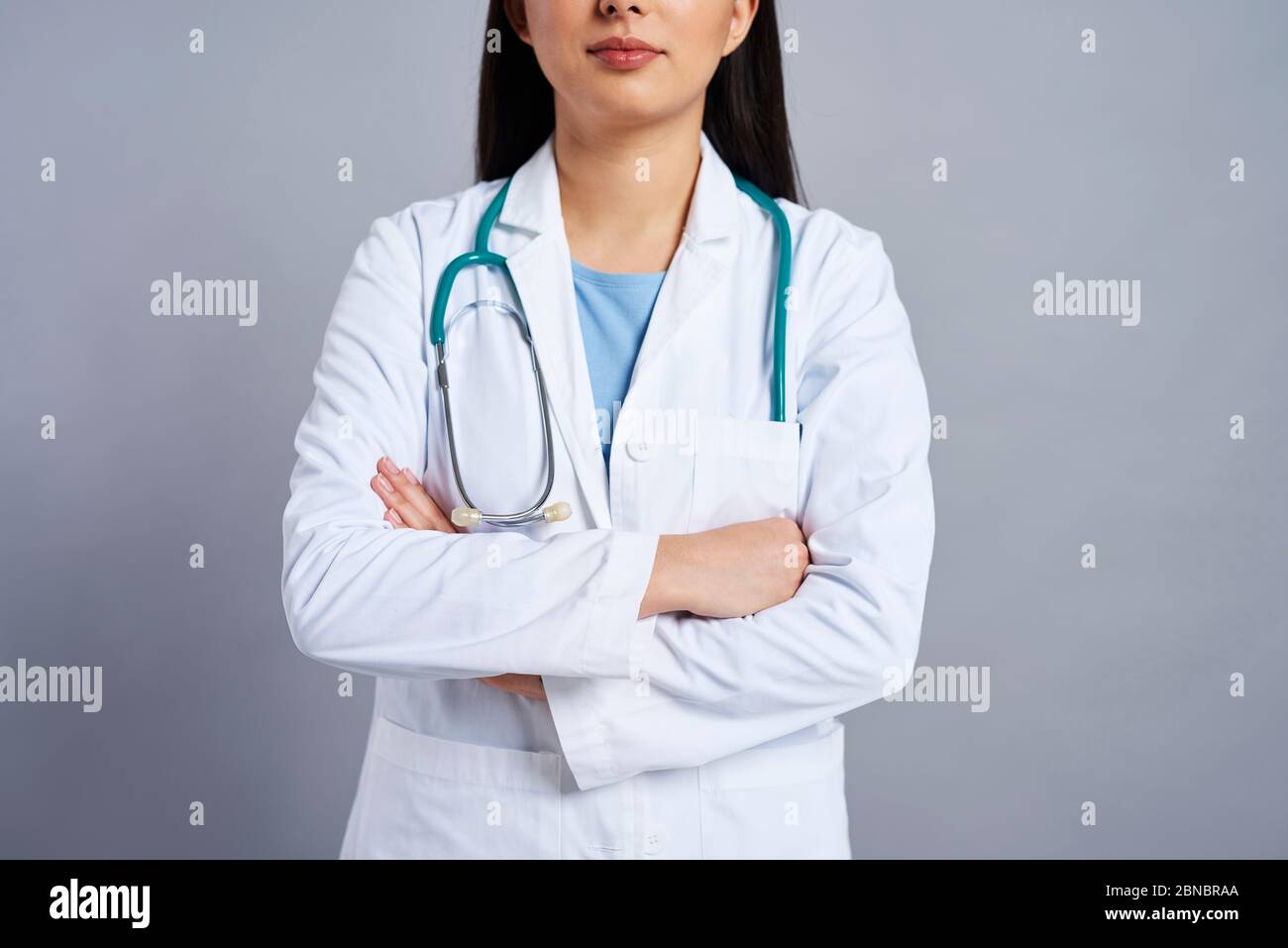 Lower section of doctor with arms crossed Stock Photo - Alamy