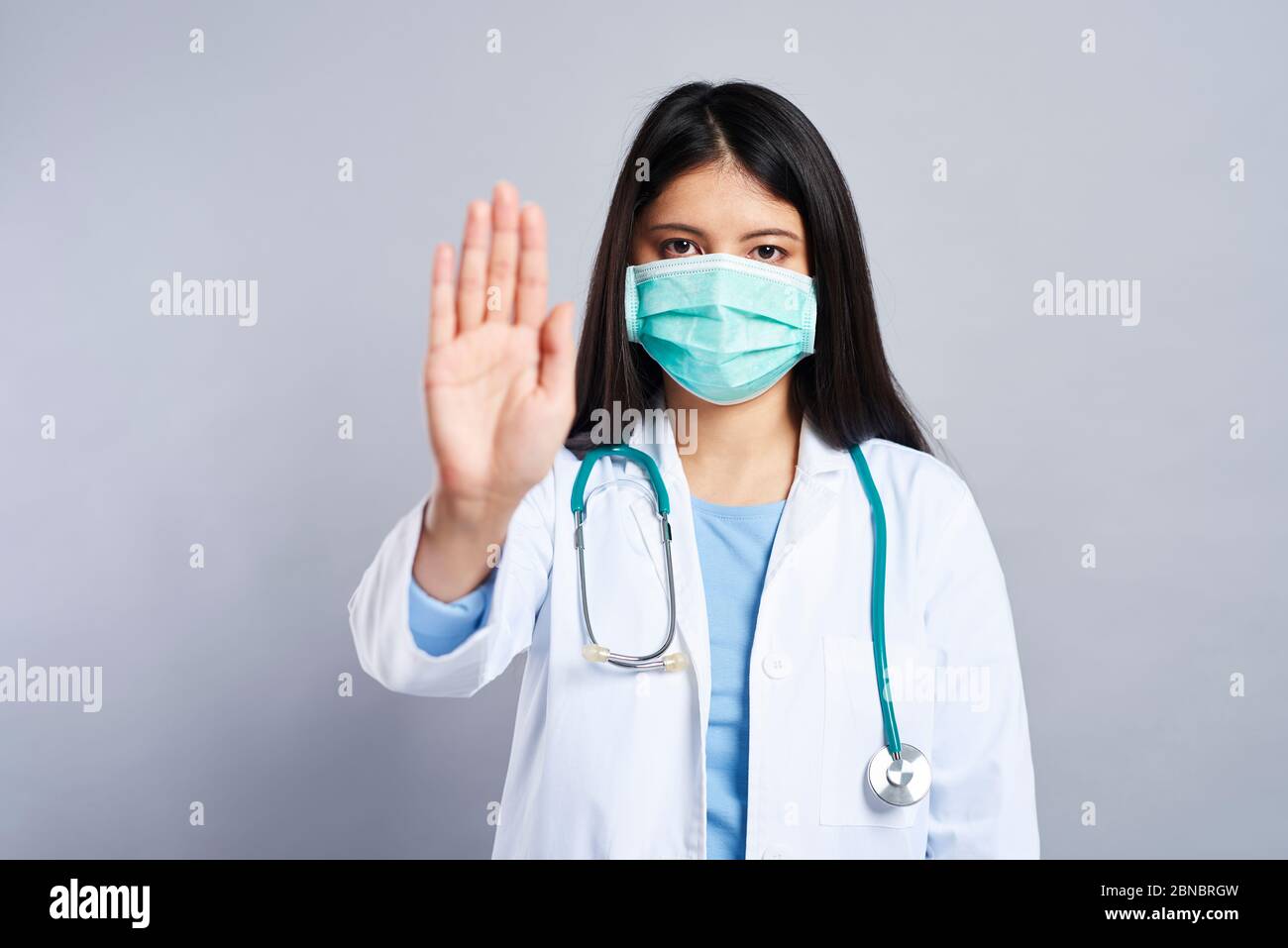 Doctor in studio shot showing stop hand sign Stock Photo - Alamy