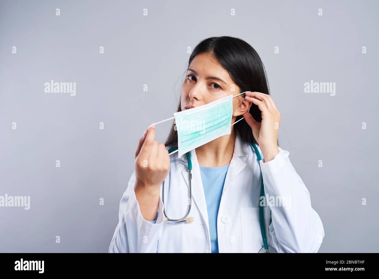 Asian female doctor starts to wear a face mask Stock Photo - Alamy