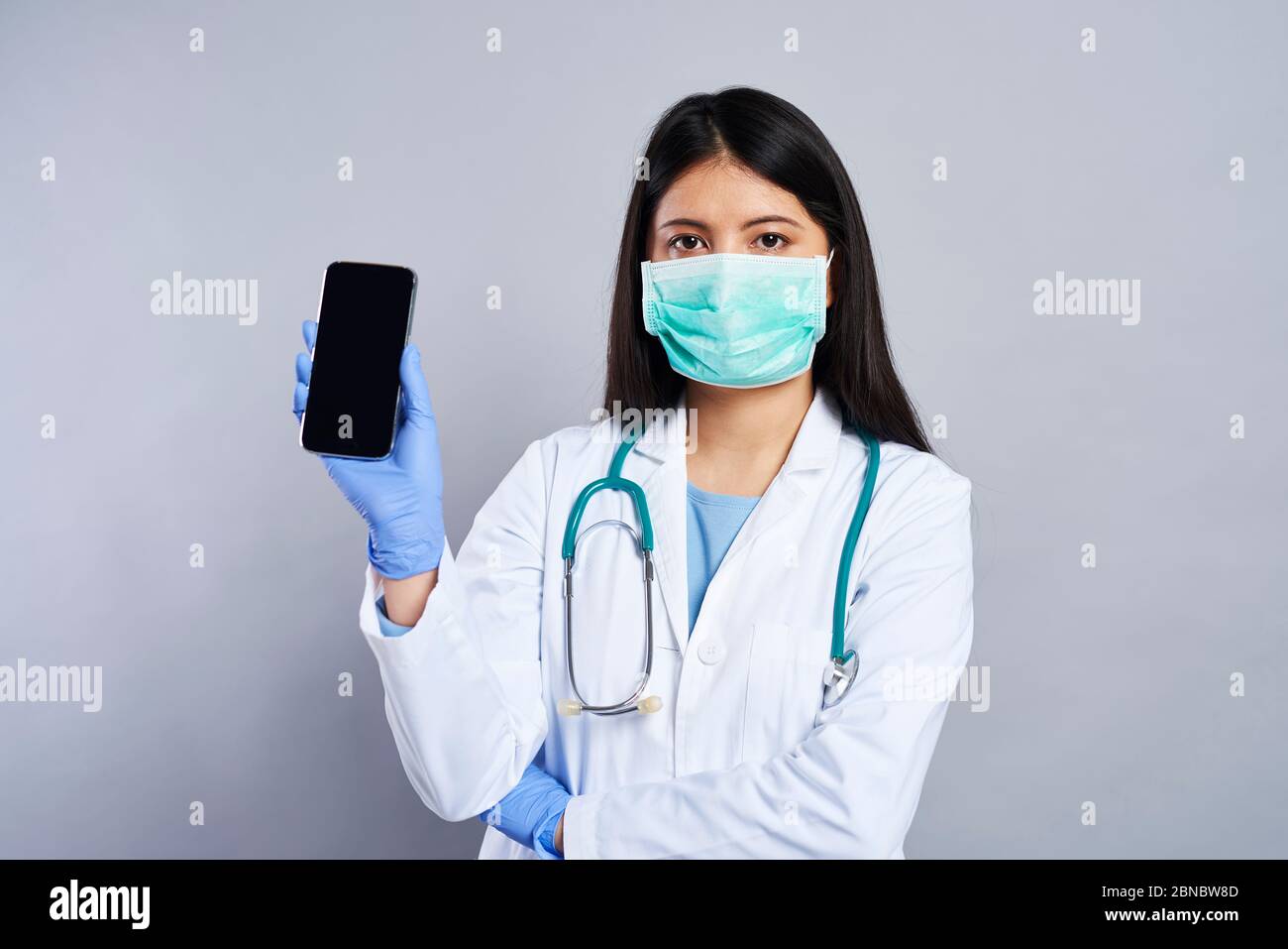 Asian doctor holding a mobile phone Stock Photo - Alamy