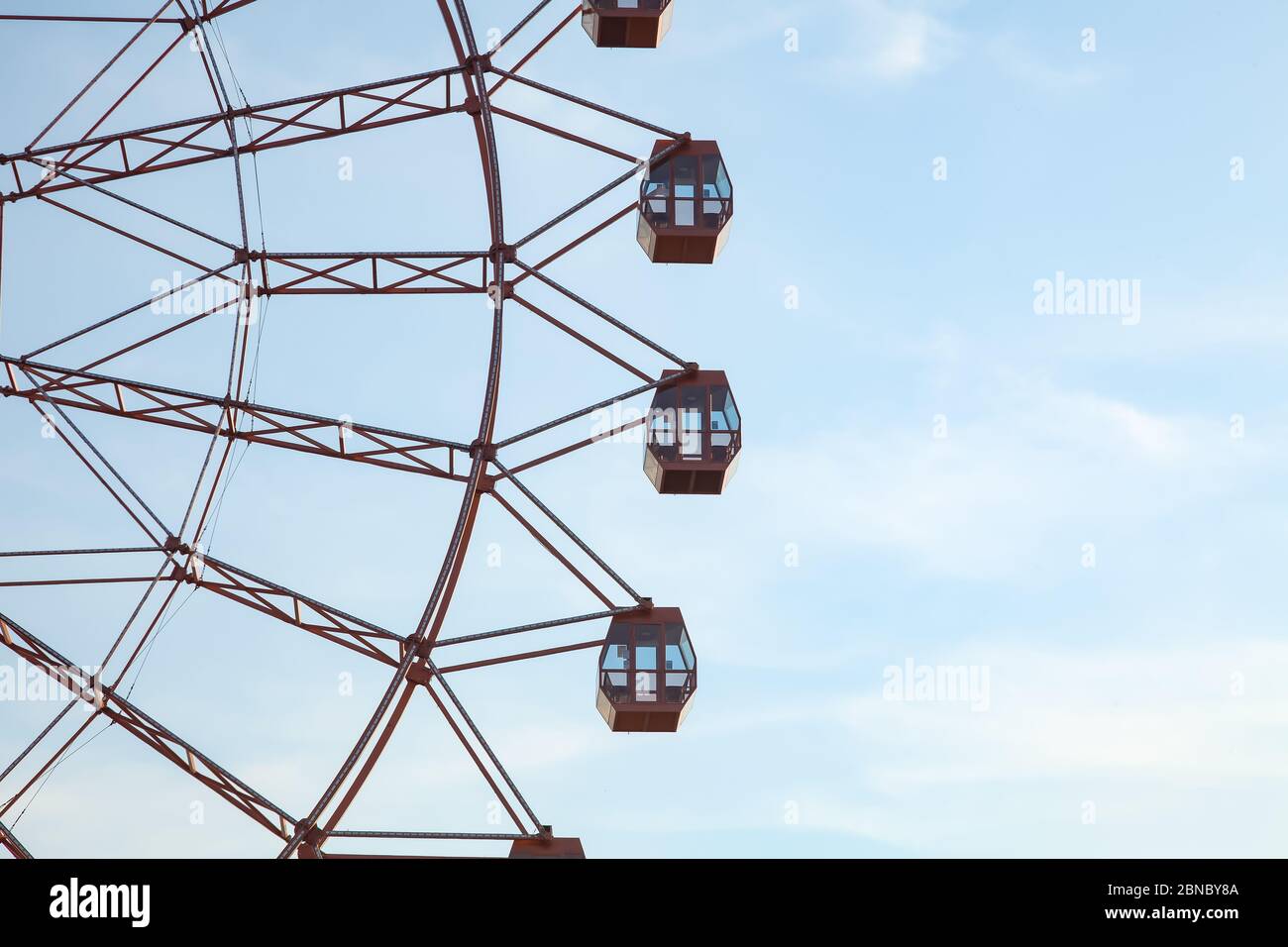 Modern ferris wheel with glazed booths on a background of blue sky ...