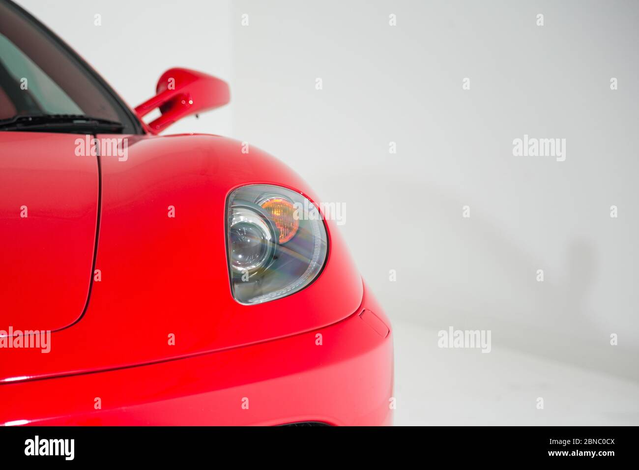 Closeup of the headlight of a red luxury car under the lights isolated ...