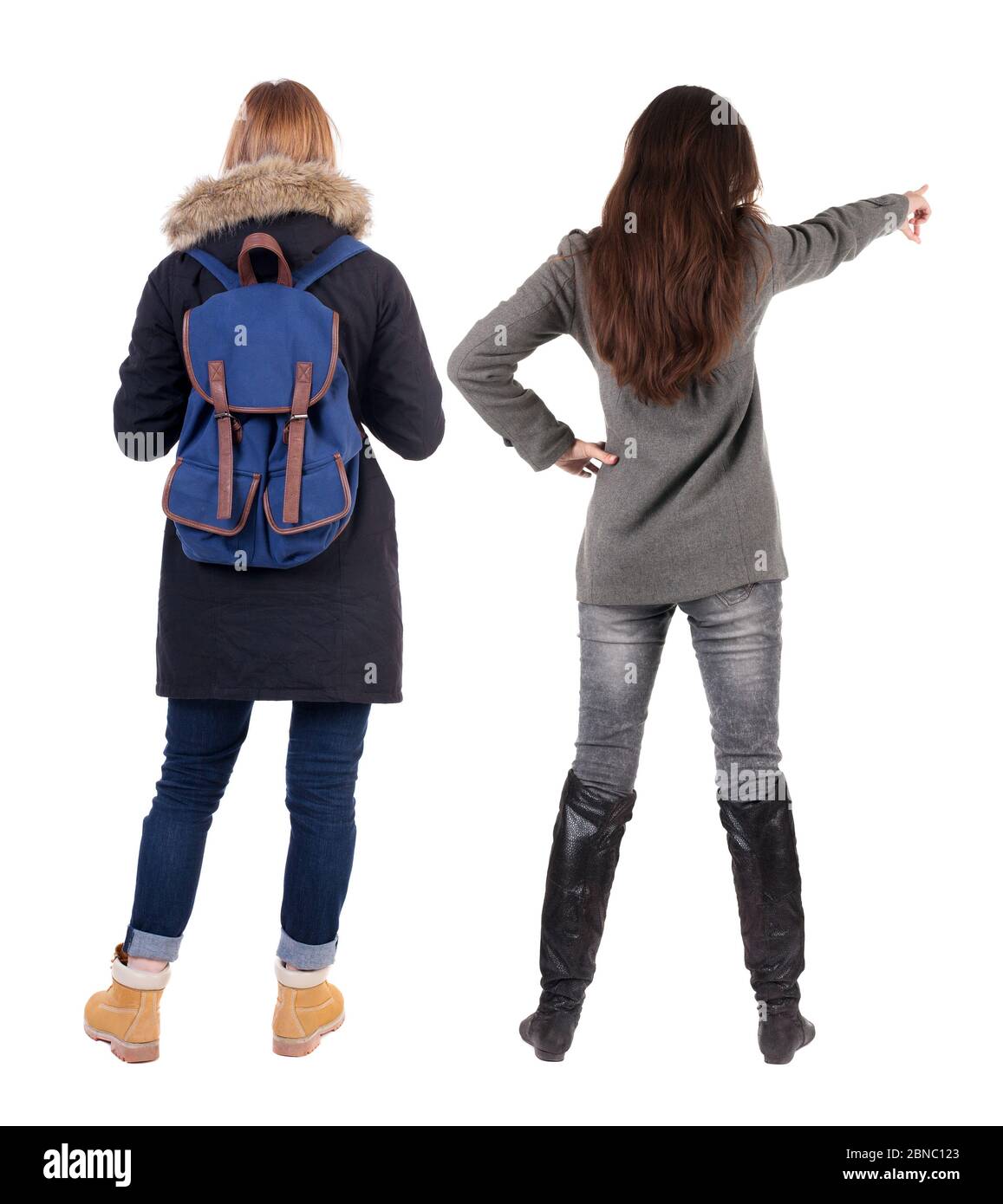 Back view of two pointing girl in winter jacket. Rear view people ...