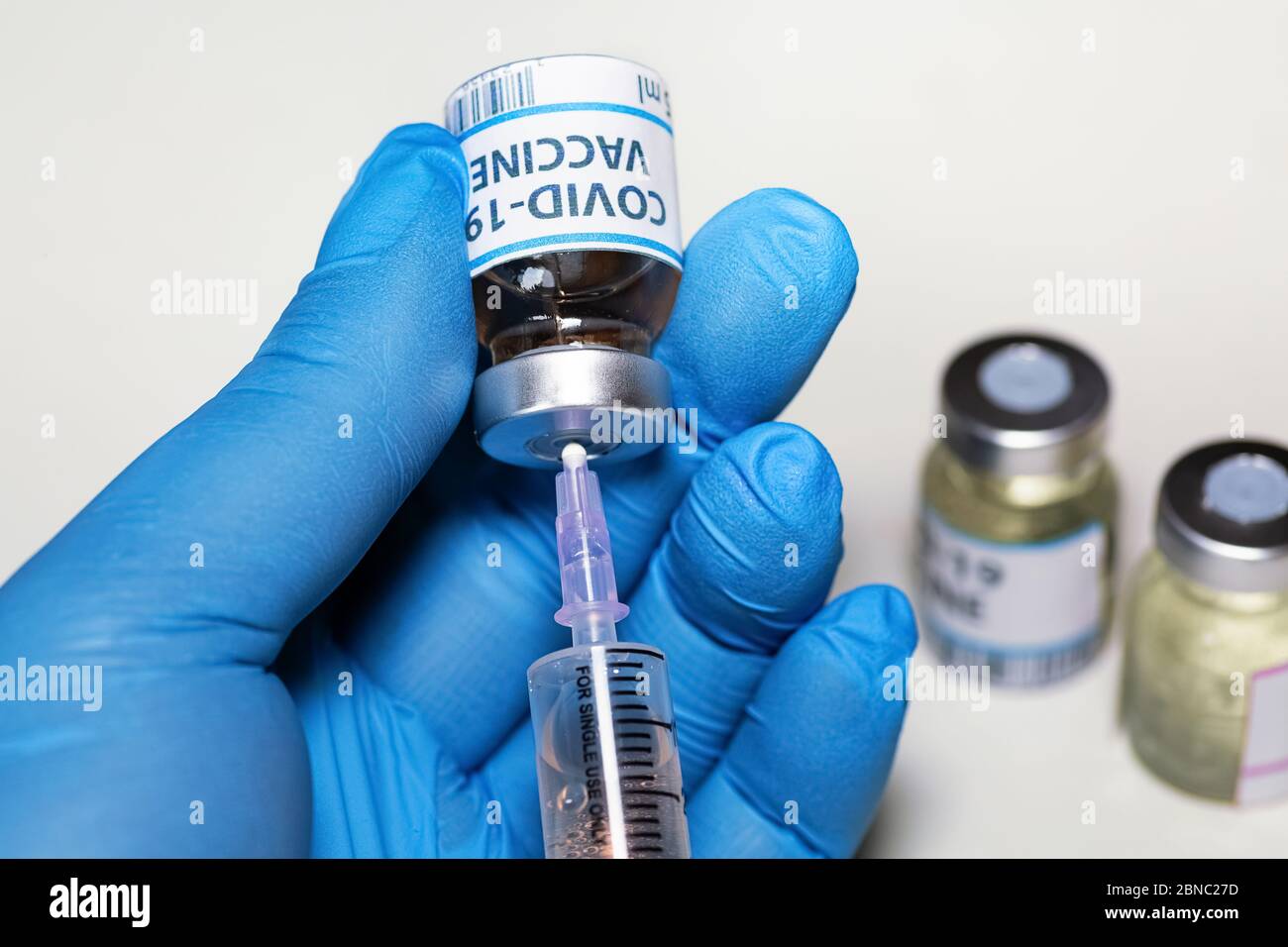 Doctor hands in medical gloves hold a vaccine bottle vial while ...