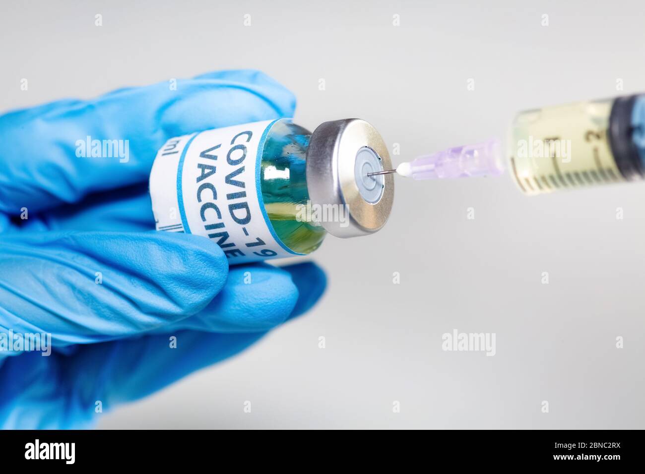 Doctor hands in medical gloves hold a vaccine bottle vial while ...