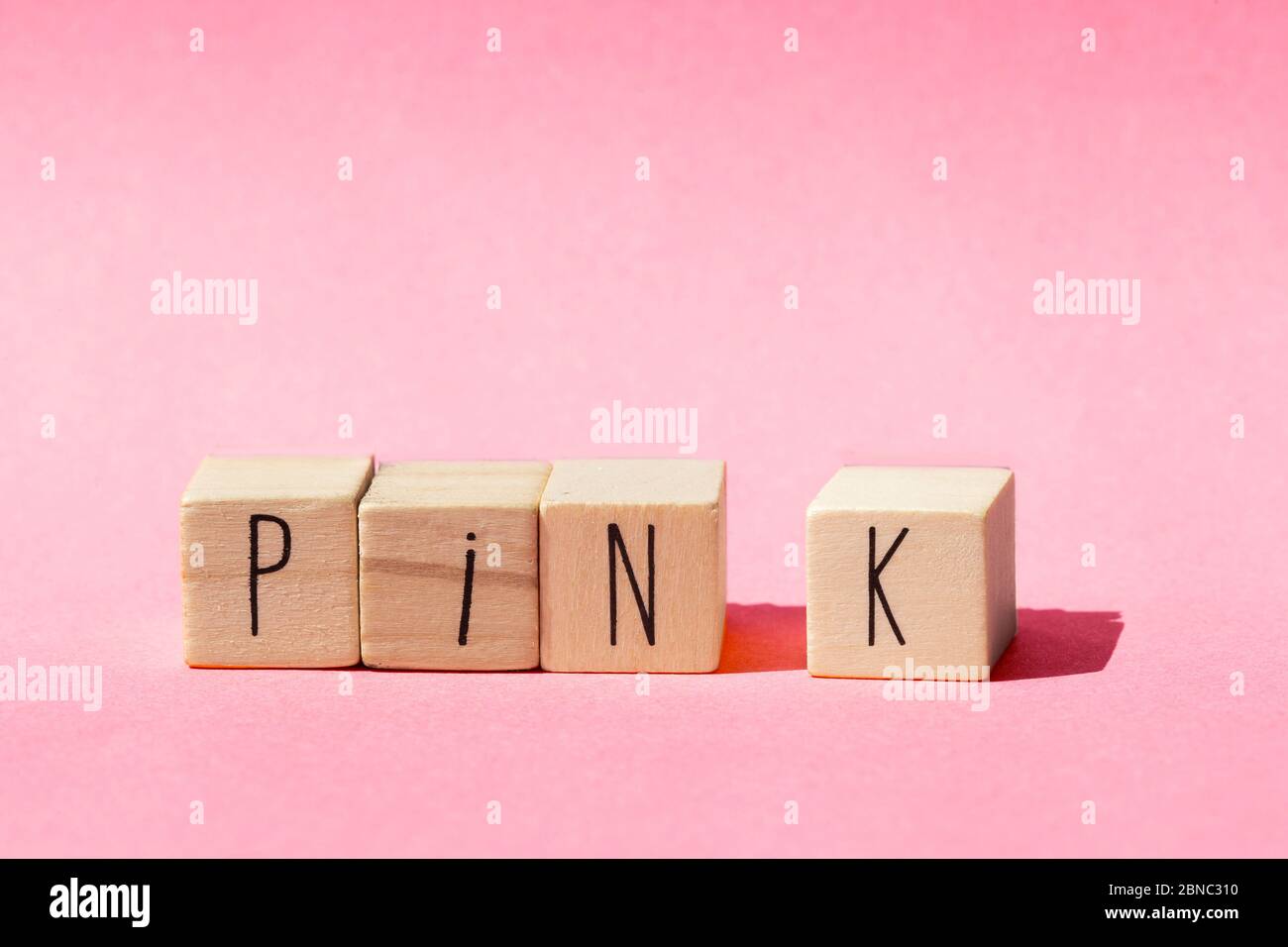 Wooden cubes lie in a row on pink background with the word Pink, Pastel ...