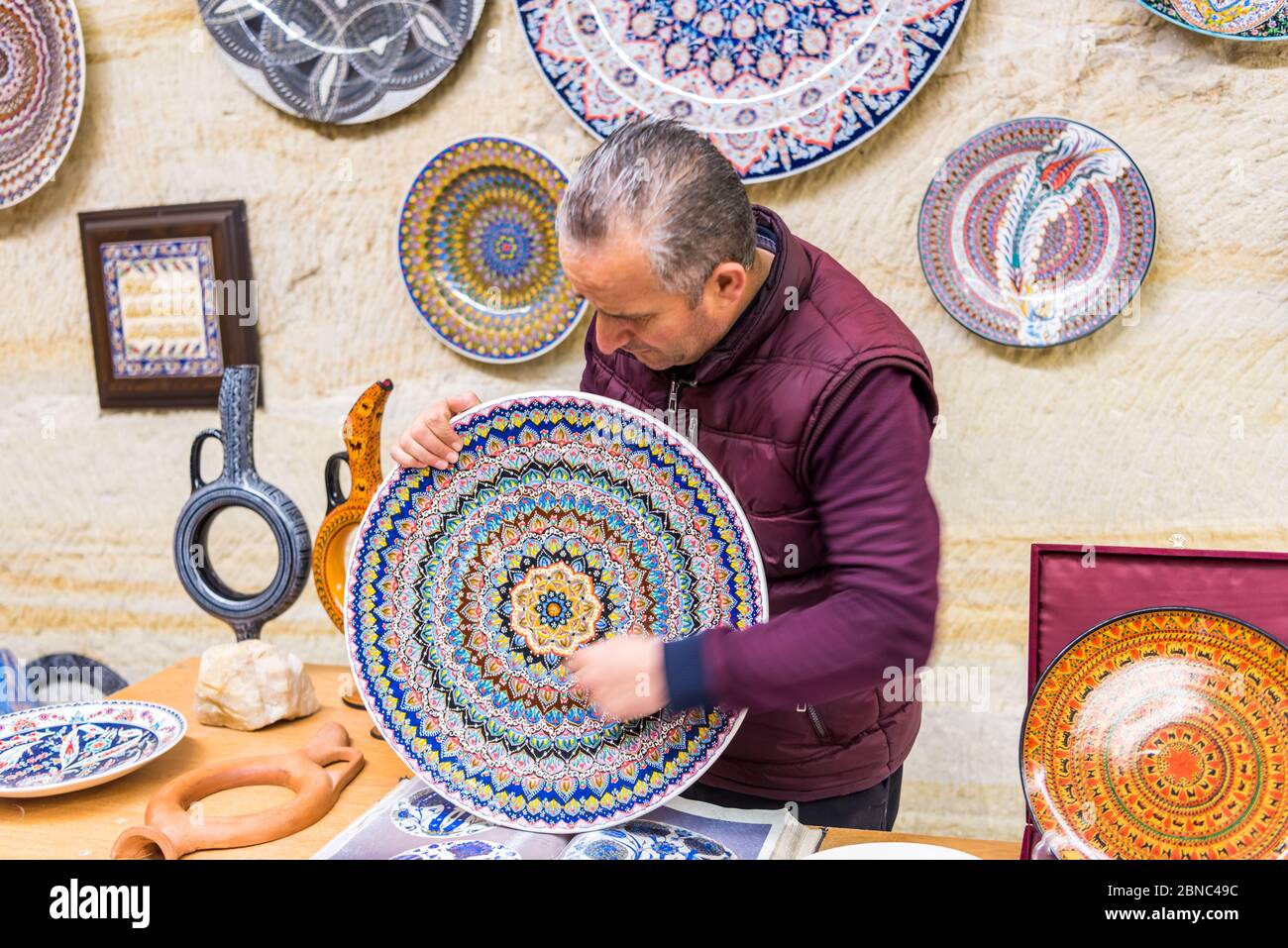 Turkish shop owner introducing the traditional ceramic pots and jars in ...
