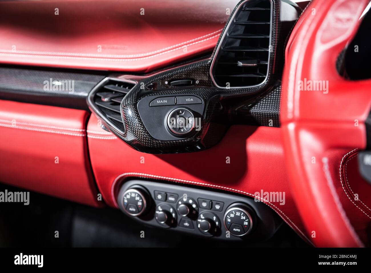 Closeup of the control buttons of a red luxury car under the lights ...