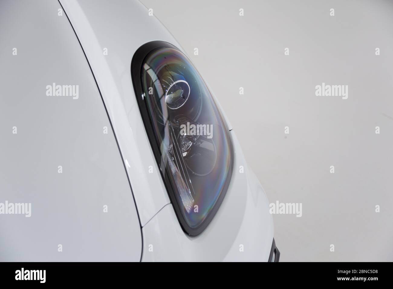 Closeup of the headlight of a luxury car under the lights against a ...