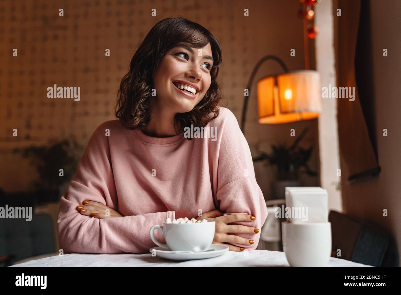 Image of a beautiful young cheerful optimistic happy woman indoors in ...