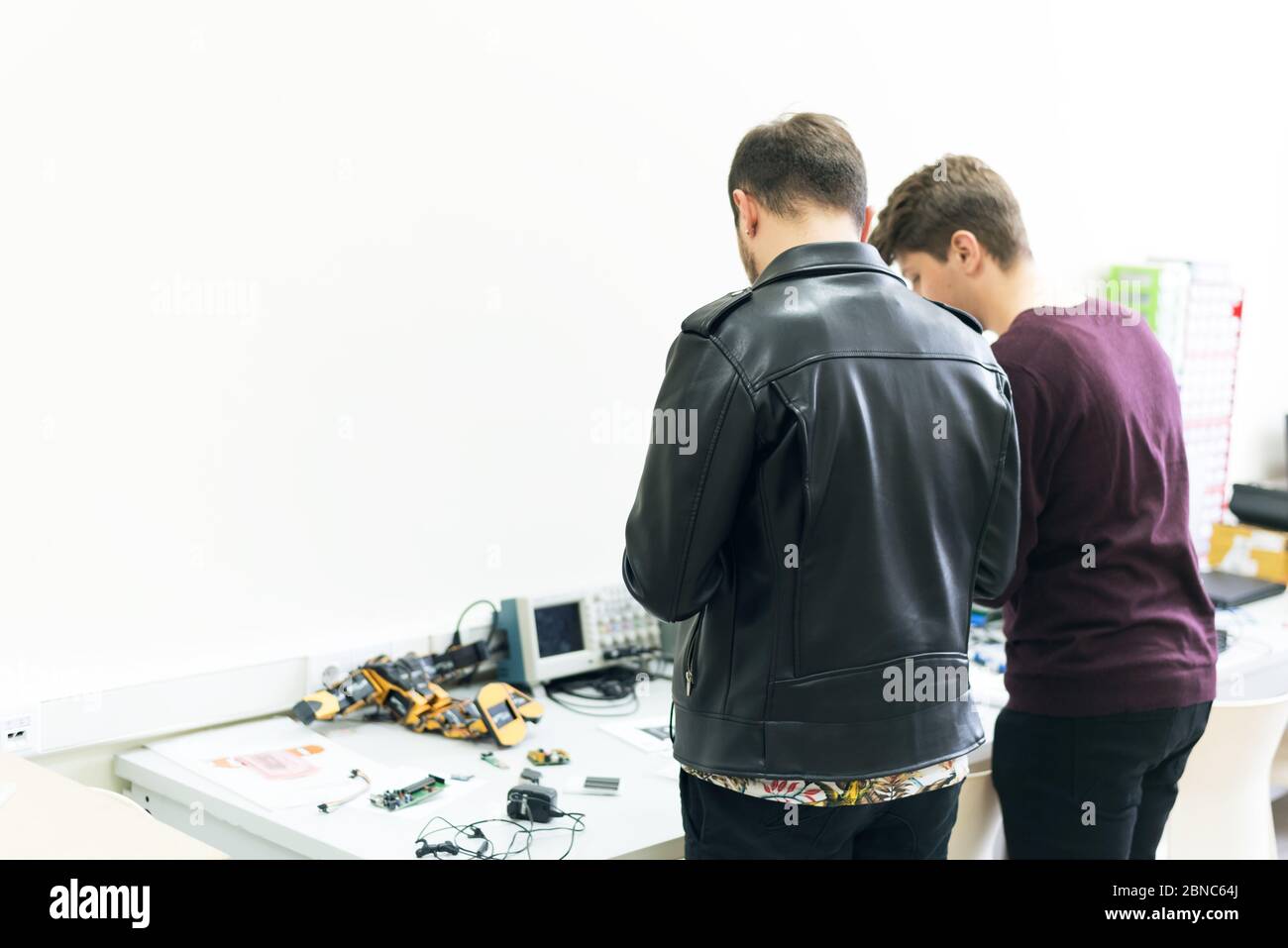 Scientists engineers designing small human robot, setting artificial ...
