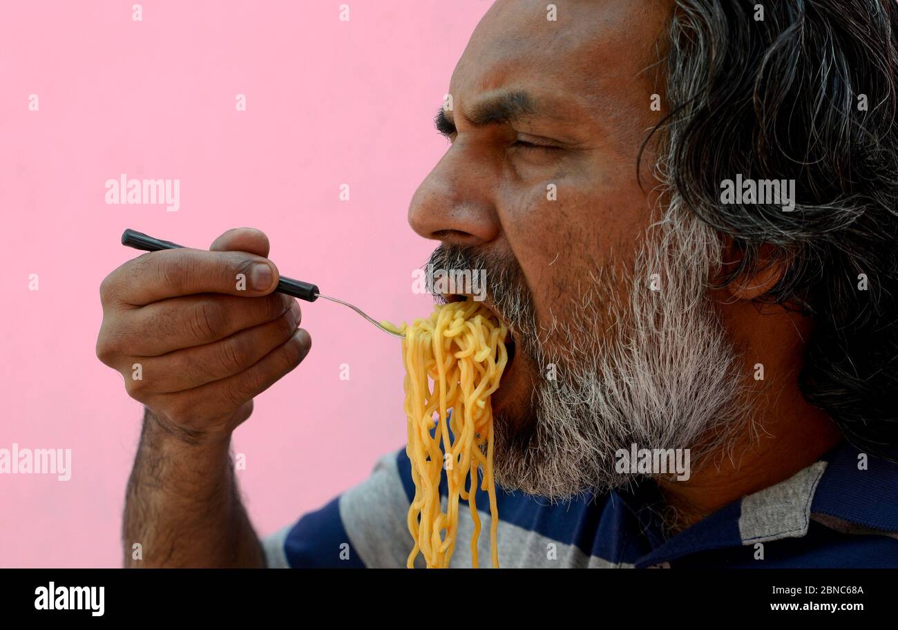 Indian man eating noodles hi-res stock photography and images - Alamy