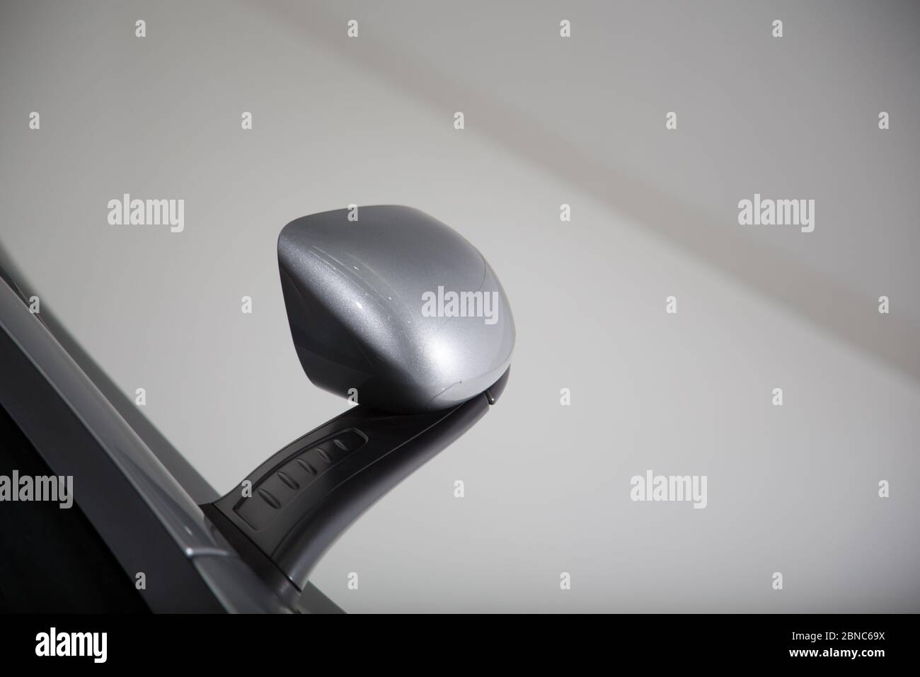 Closeup of a silver shiny side-view mirror of a luxury car under the ...