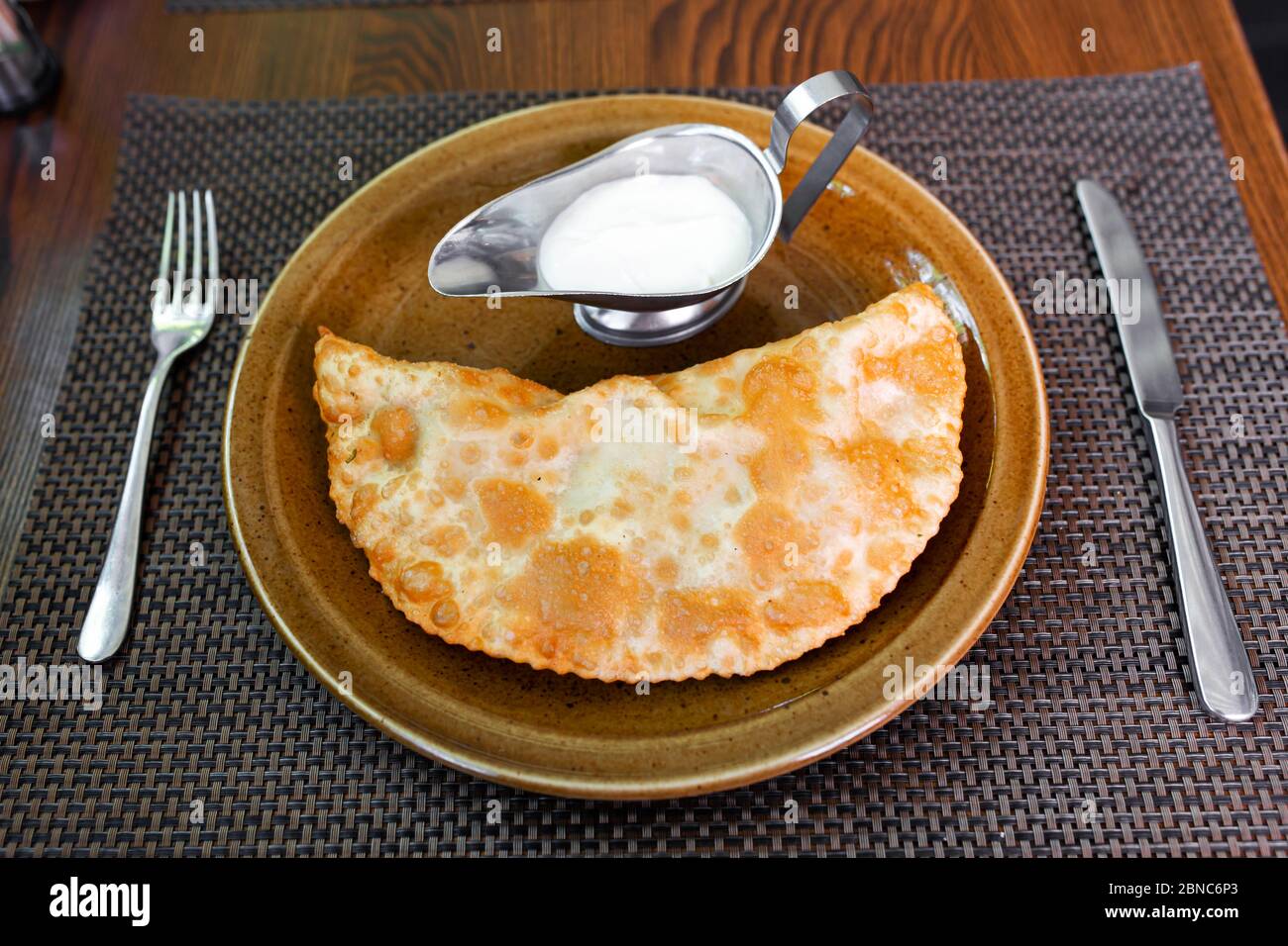 Juicy cheburek with sour cream. Crimean Tatar cuisine. Meat pie Stock ...