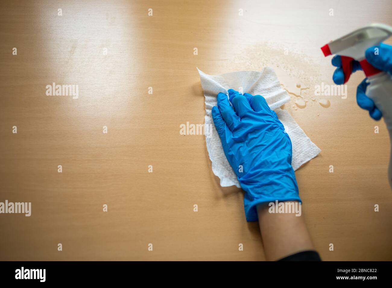 Cleaning home office table sanitizing kitchen table surface with ...