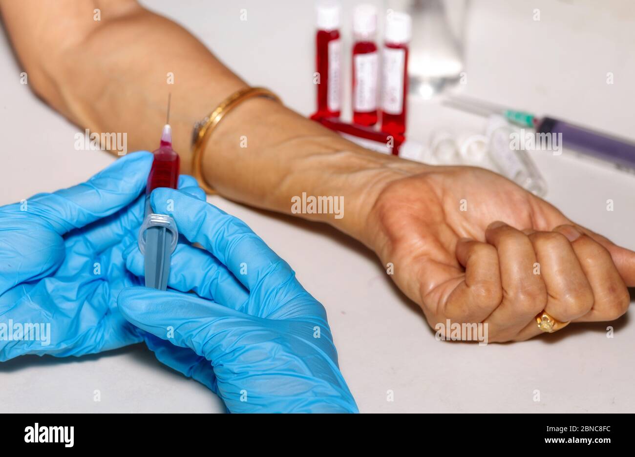 Hands of a medical worker holding an injection syringe with blood ...