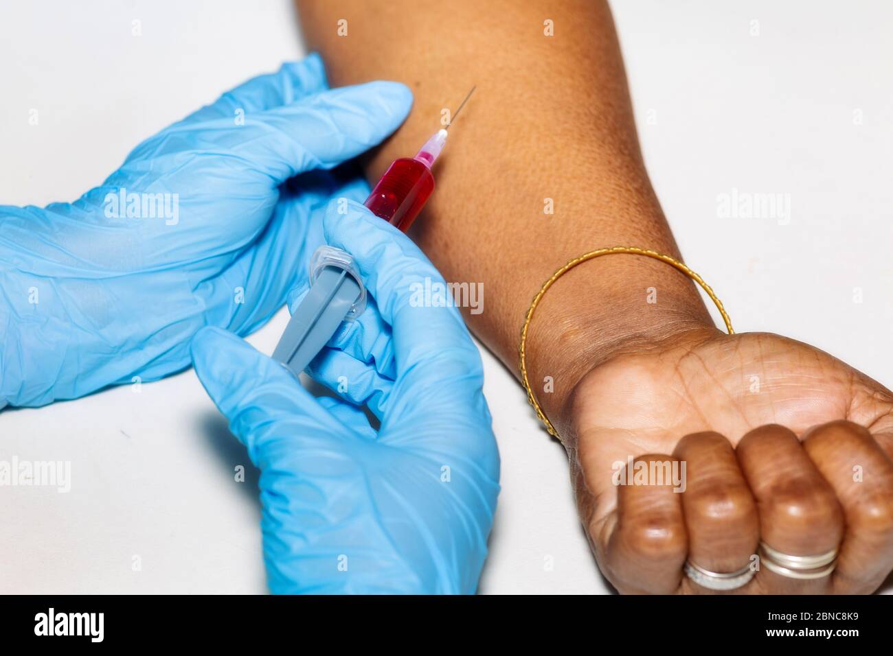 Hands of a medical worker holding an injection syringe with blood ...