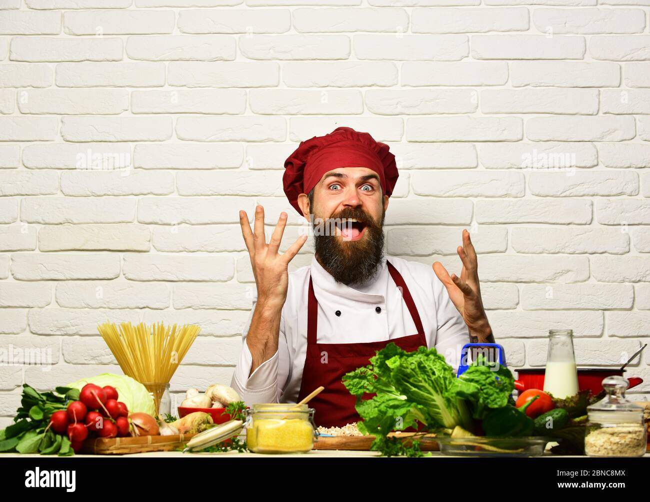 Cooking process concept. Cook with excited face in uniform sits by ...