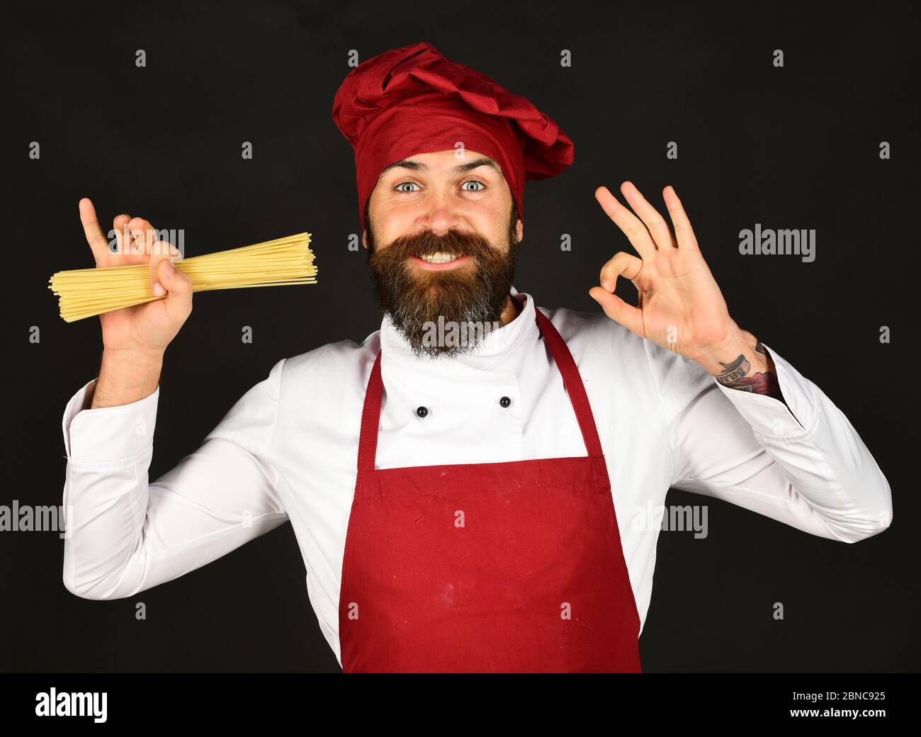 Italian restaurant concept. Cook with smile in burgundy hat and apron ...
