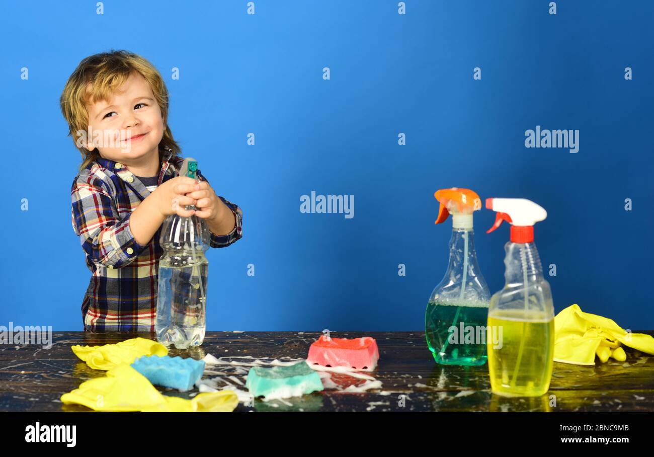 Cleaning activities concept. Child near wooden table with cleaning ...